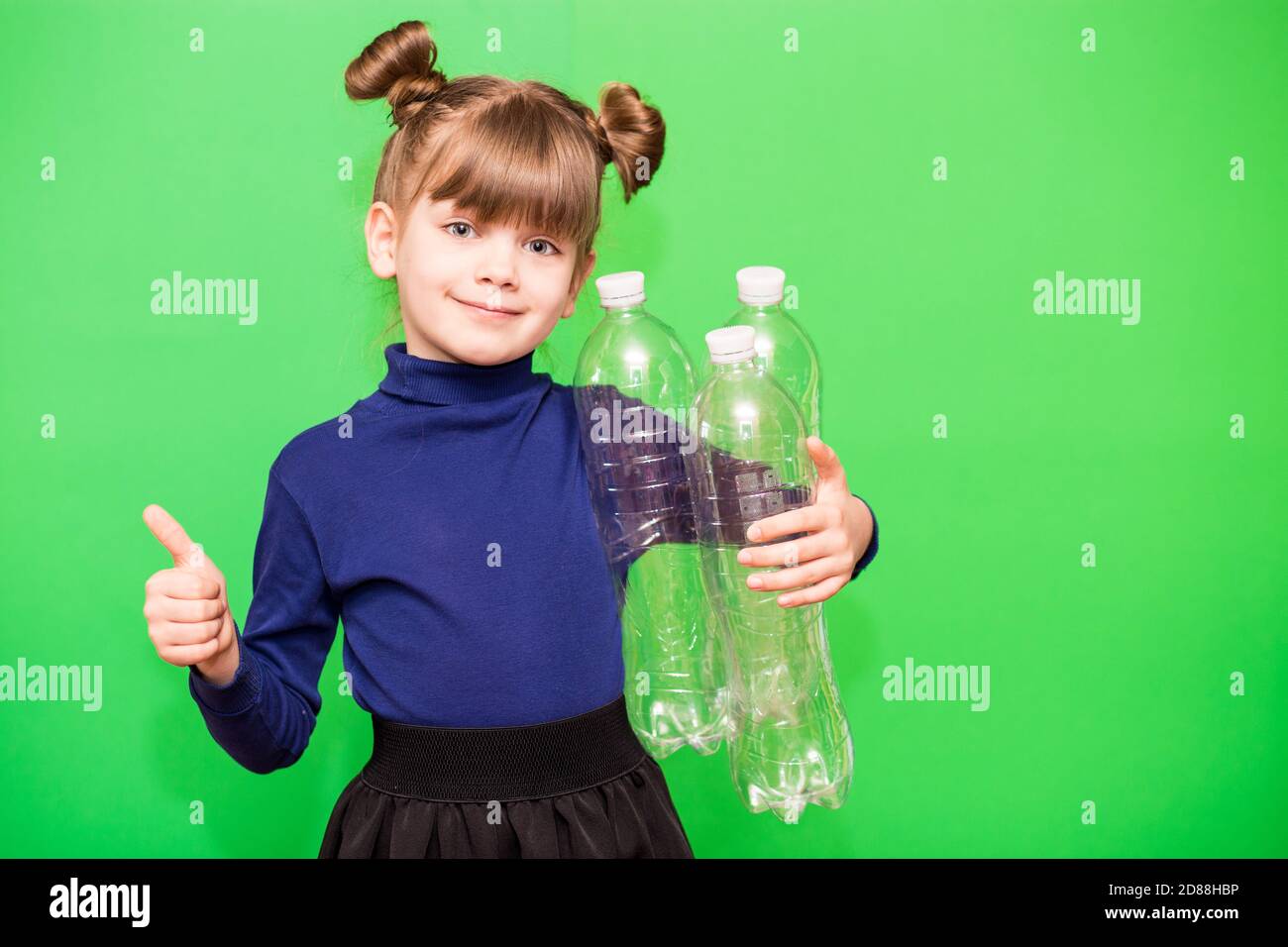 Positive little ecologist girl holding trash bag with plastic bottles ...
