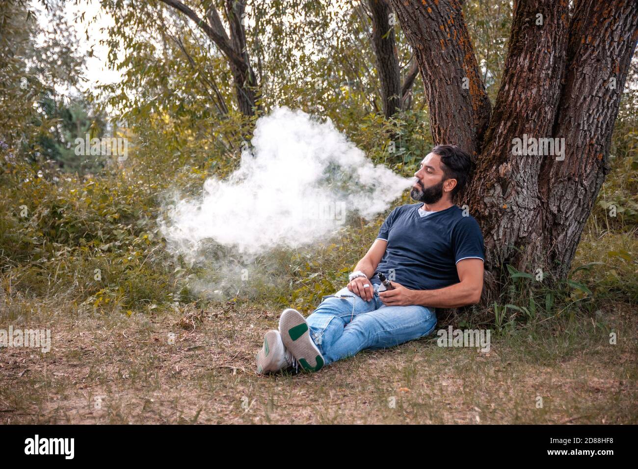 Bearded smoker enjoying an vape in the fresh air. The new technology ...