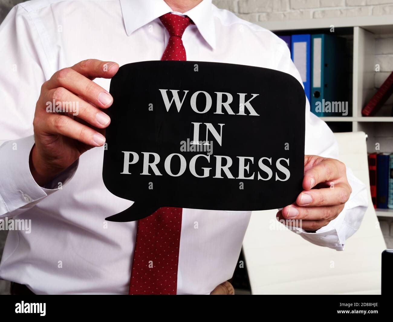 Manager shows Work In Progress quote plate Stock Photo - Alamy