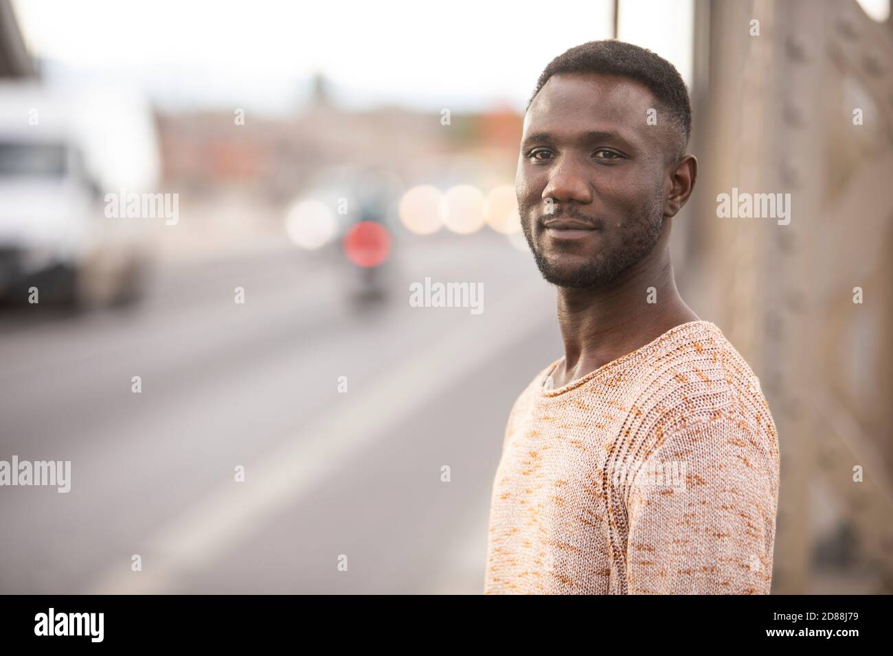 Handsome black man portrait with blurred traffic background. Focus on ...