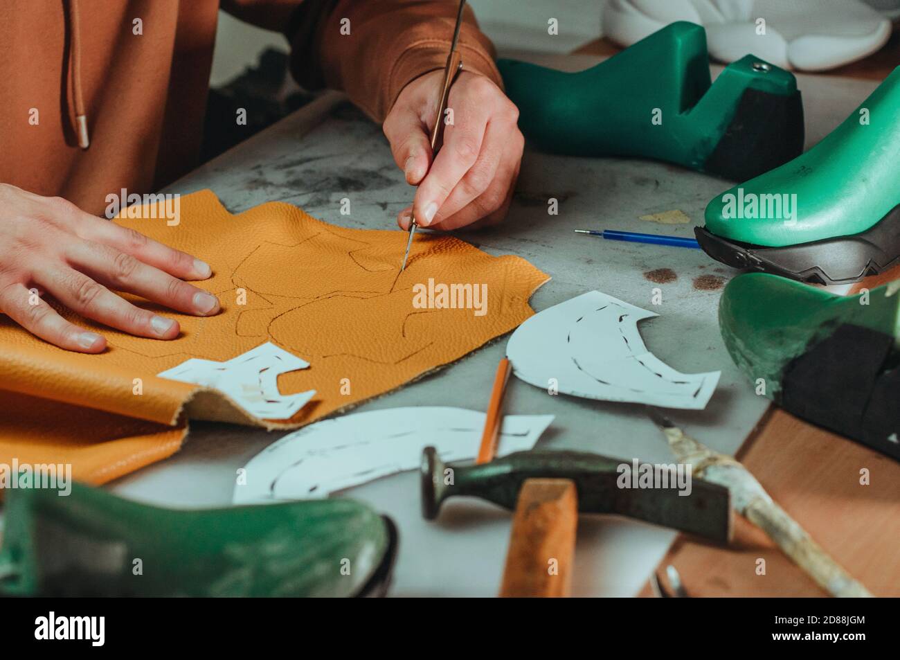 Shoemaker cutting patterns using knife from leather Stock Photo - Alamy