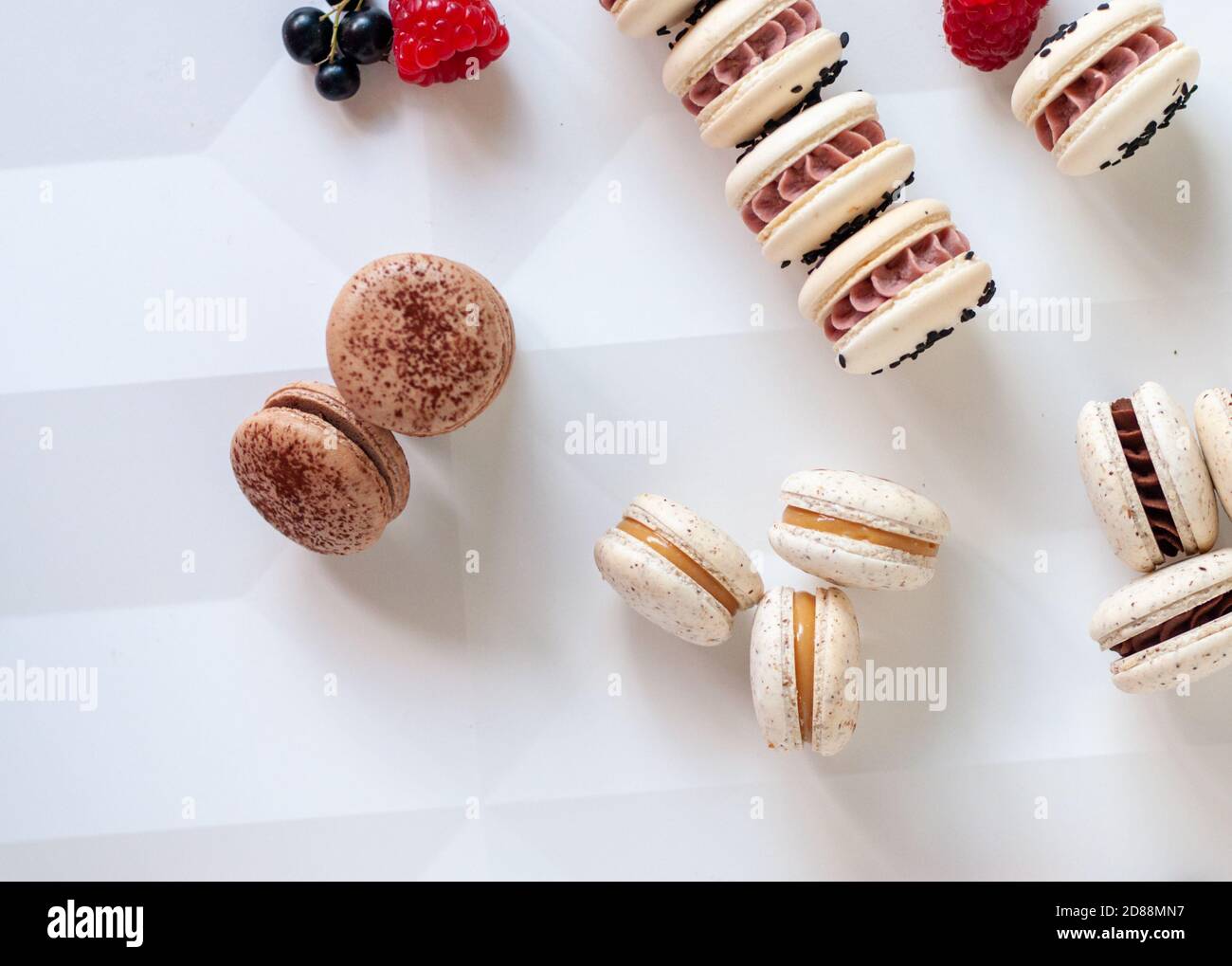 Macarons and berries on white table Stock Photo - Alamy