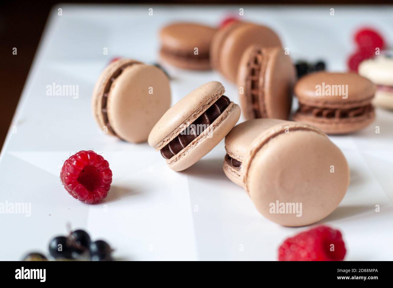 Macarons and berries on white table Stock Photo - Alamy