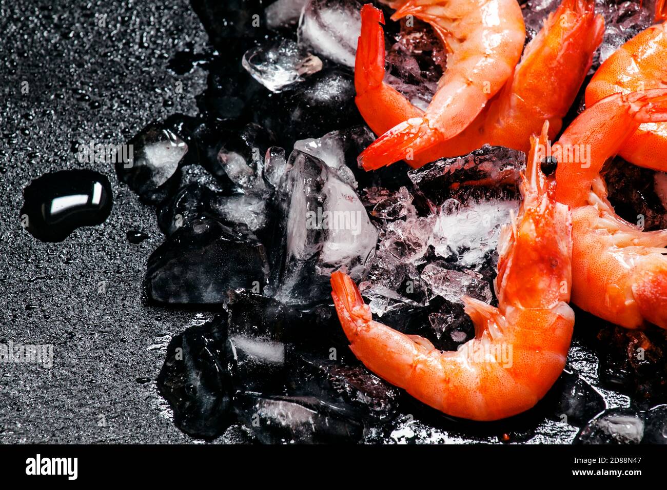 Food background, frozen cooked shrimp with ice, black background, top ...