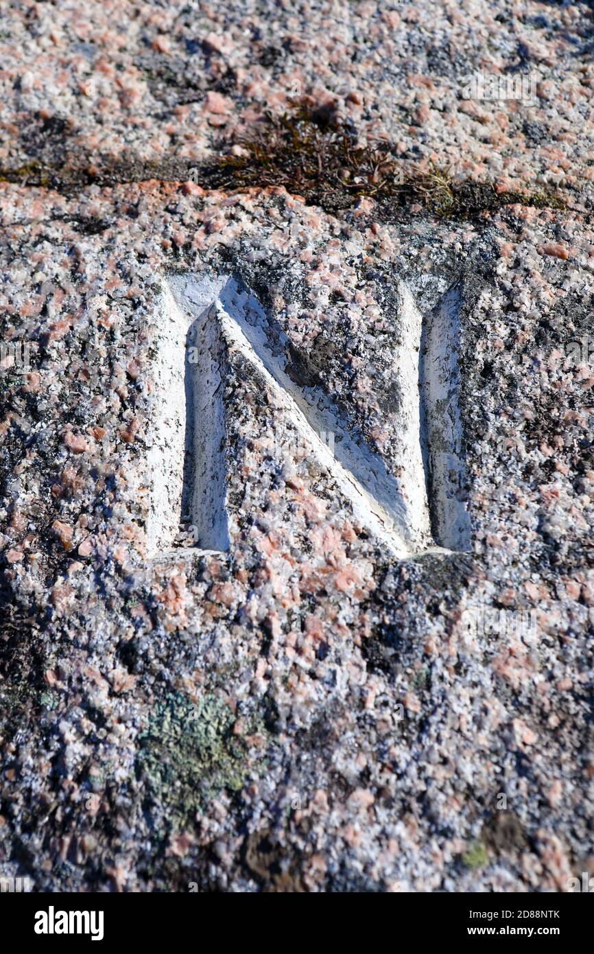 The letter N, indicating the direction of north, carved into a pink ...
