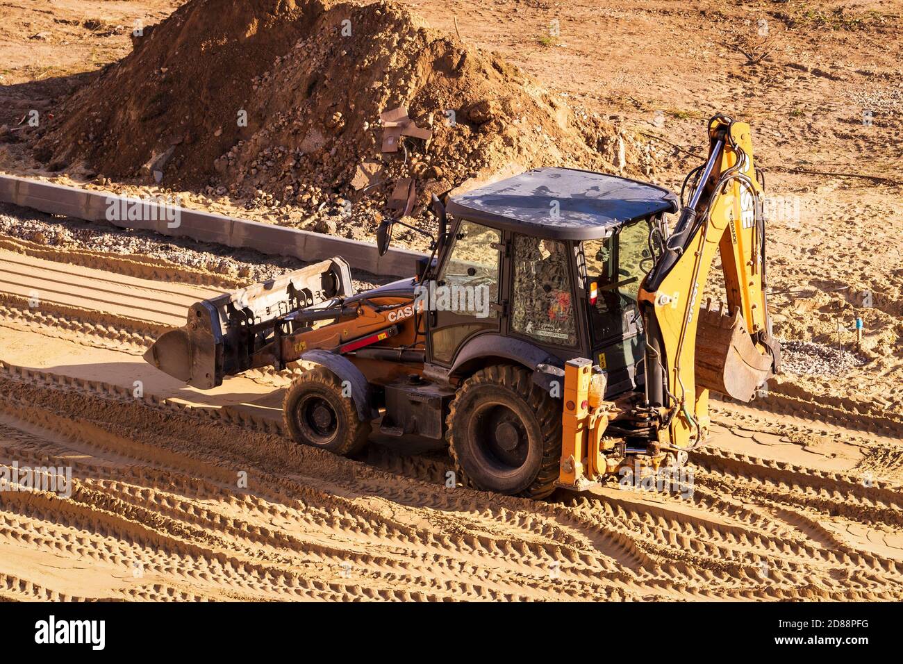 Russia, Kaluga - OCTOBER 27, 2020: Tractor with a bucket leveling sand ...
