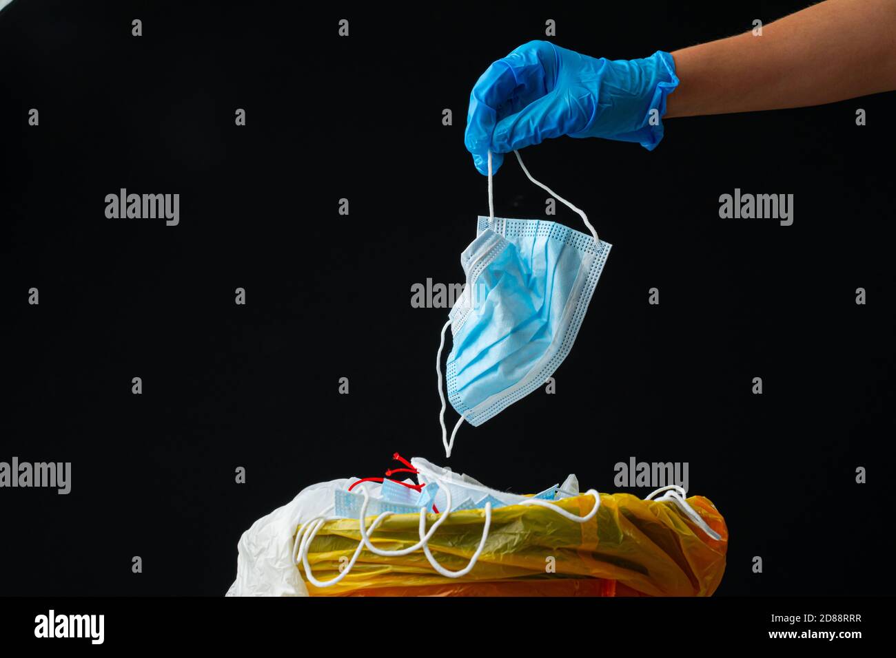 Hand putting used dirty surgical mask to a garbage bin Stock Photo - Alamy