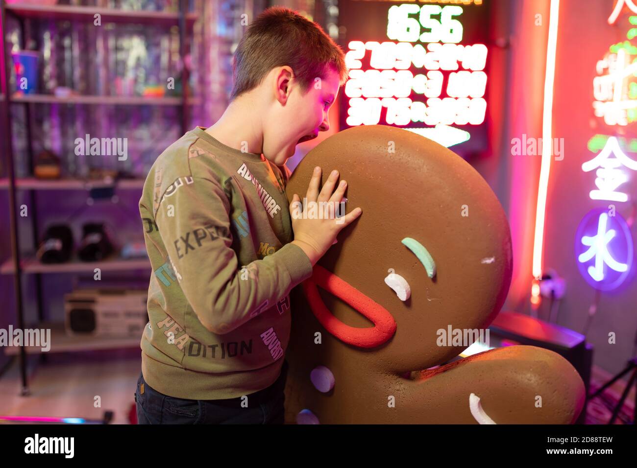 the boy bites a big gingerbread man Stock Photo - Alamy
