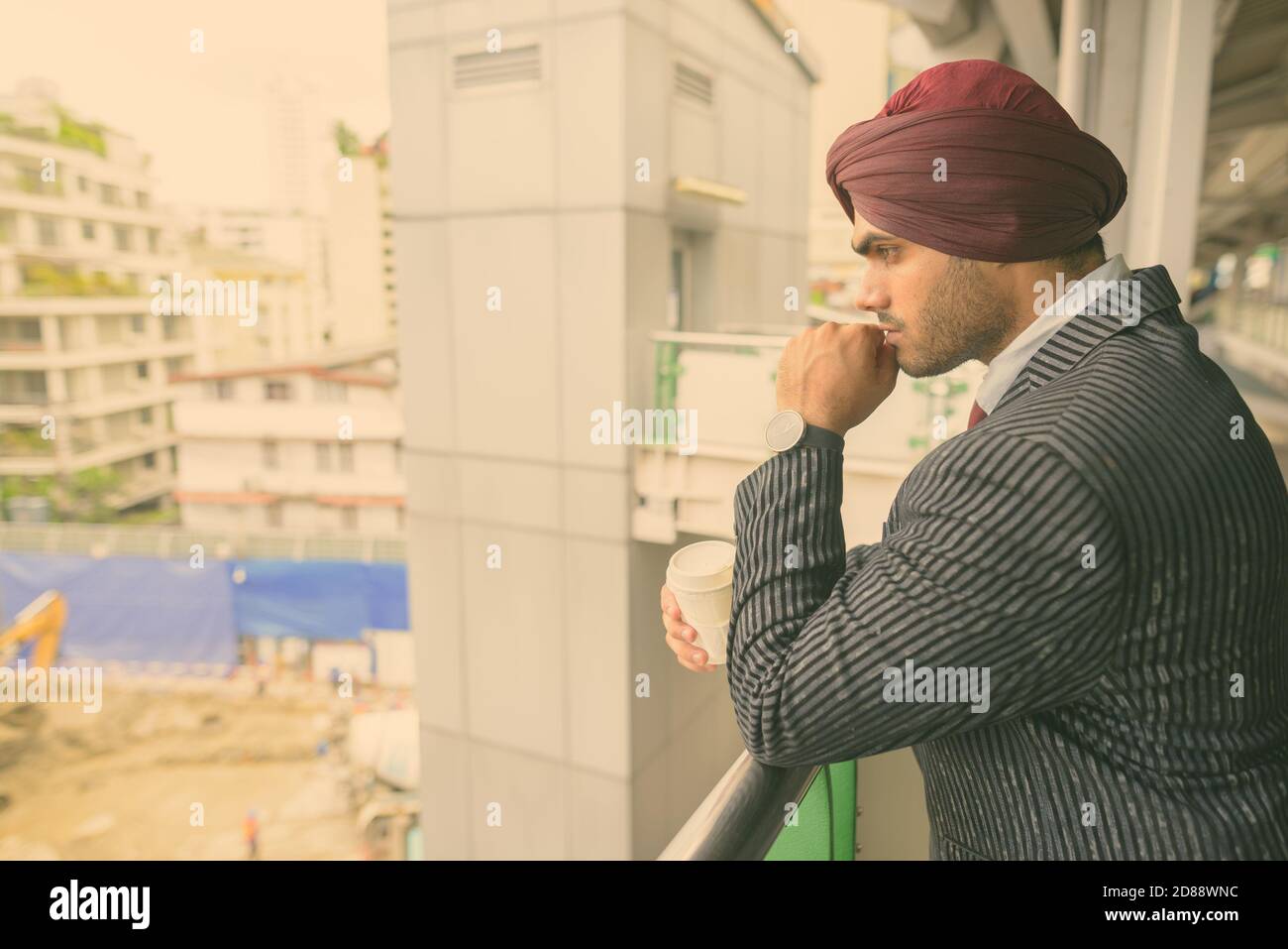 Young handsome Indian Sikh businessman wearing turban while exploring ...