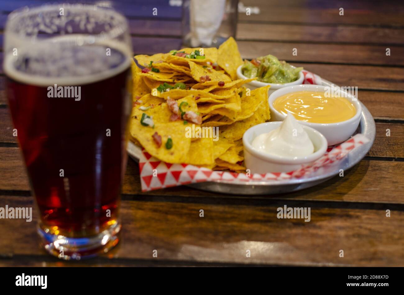 Pint of beer and nachos with cheddar and cream cheese Stock Photo - Alamy