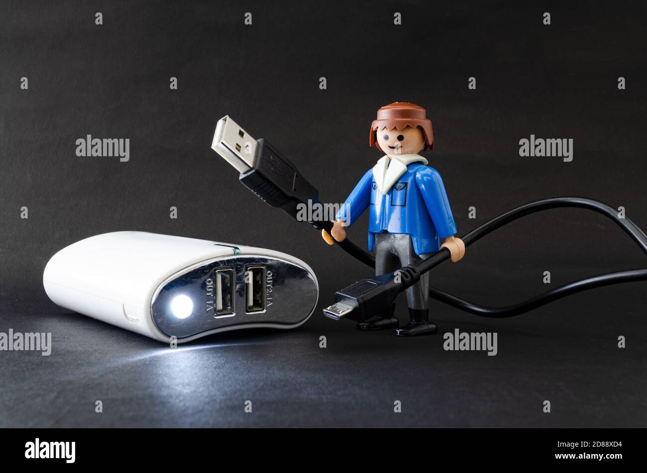 Lego man holding a USB cable on black background Stock Photo - Alamy
