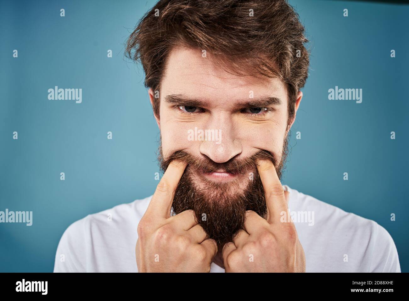 Bearded man displeased facial expression emotions close-up blue ...