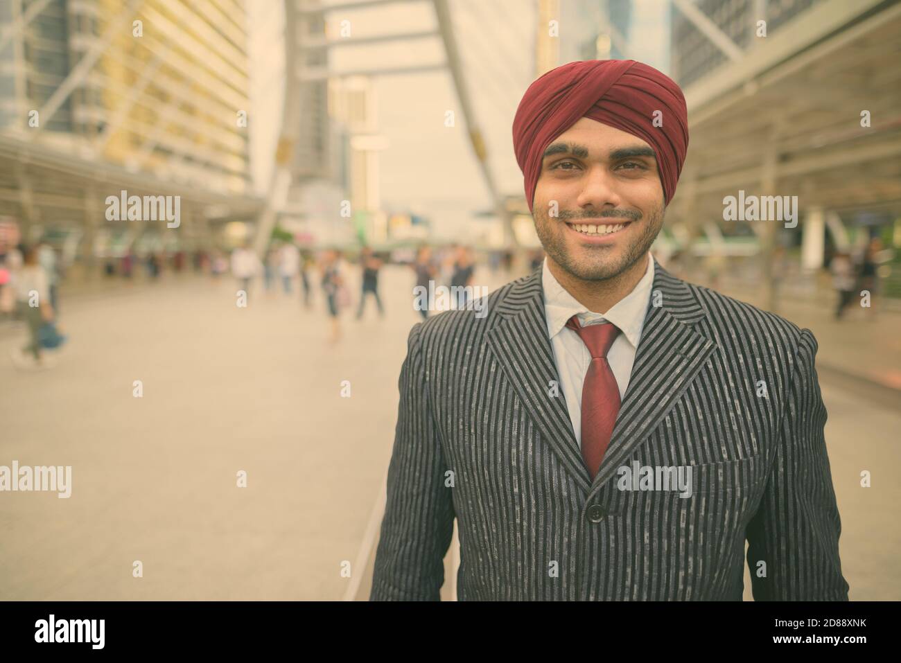 Young handsome Indian Sikh businessman wearing turban while exploring ...