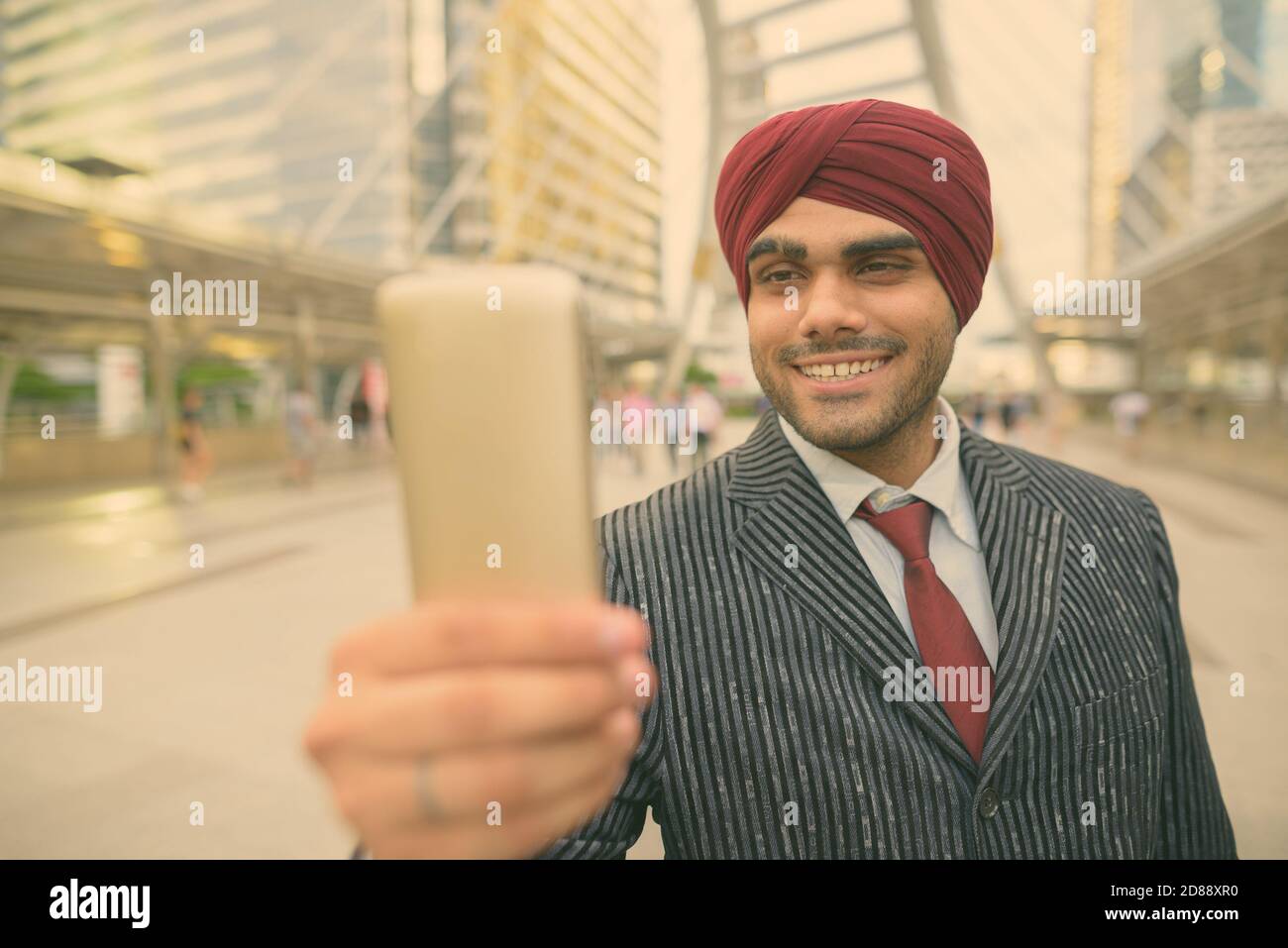 Young handsome Indian Sikh businessman wearing turban while exploring ...