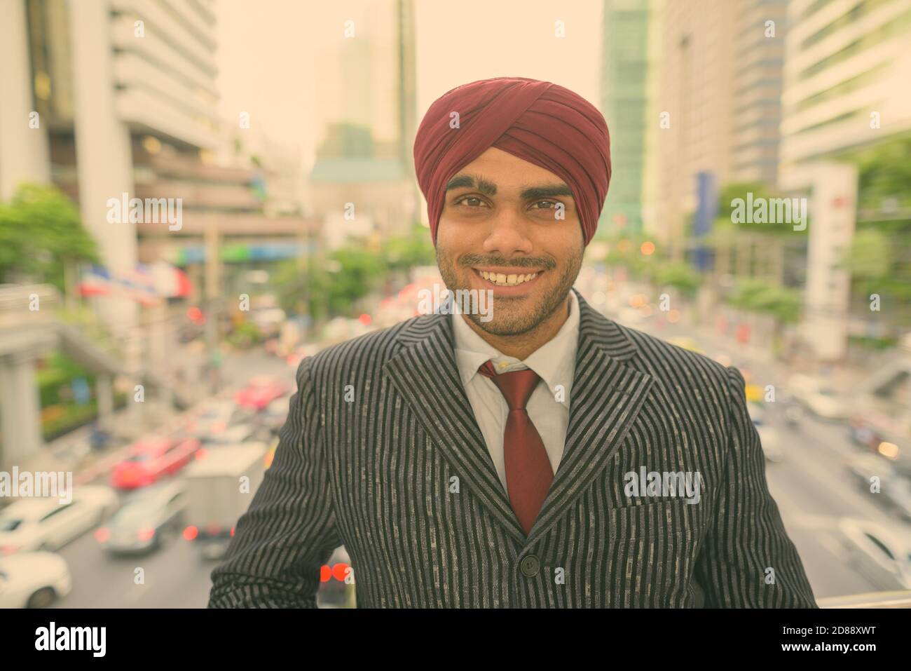 Young handsome Indian Sikh businessman wearing turban while exploring ...