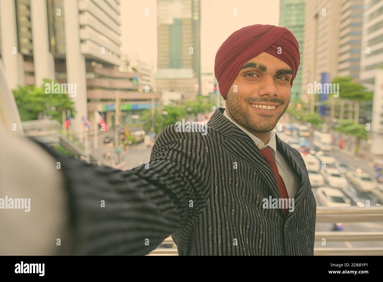 Young handsome Indian Sikh businessman wearing turban while exploring ...