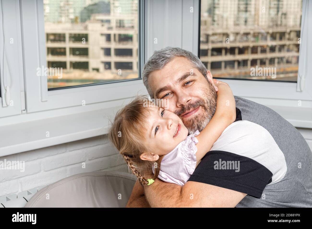 adult gray-haired father hugs little daughter and is happy. family ...