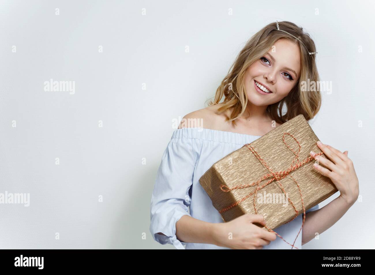 beautiful young girl holding a box with a gift and happy. empty space ...