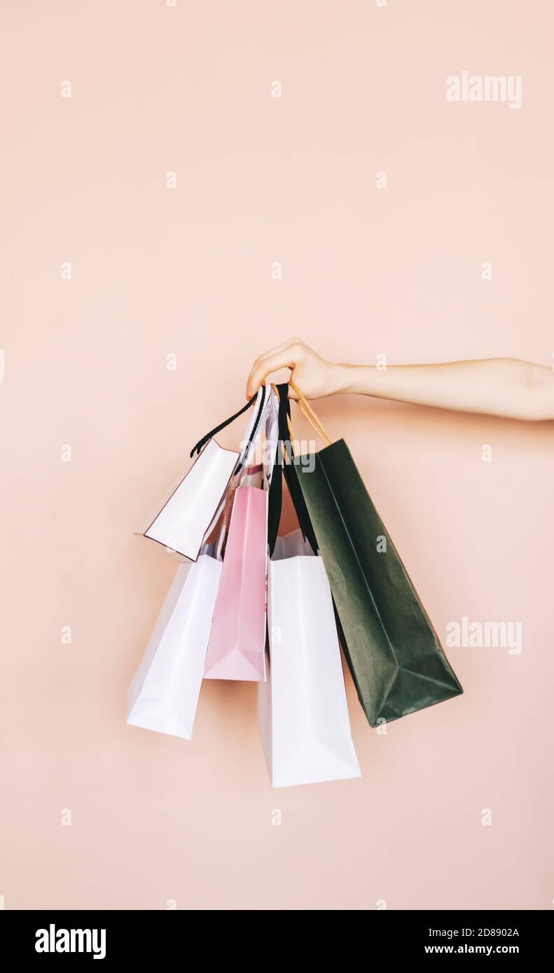 Shopping bags in hands isolated on beige pastel background. Shopping ...