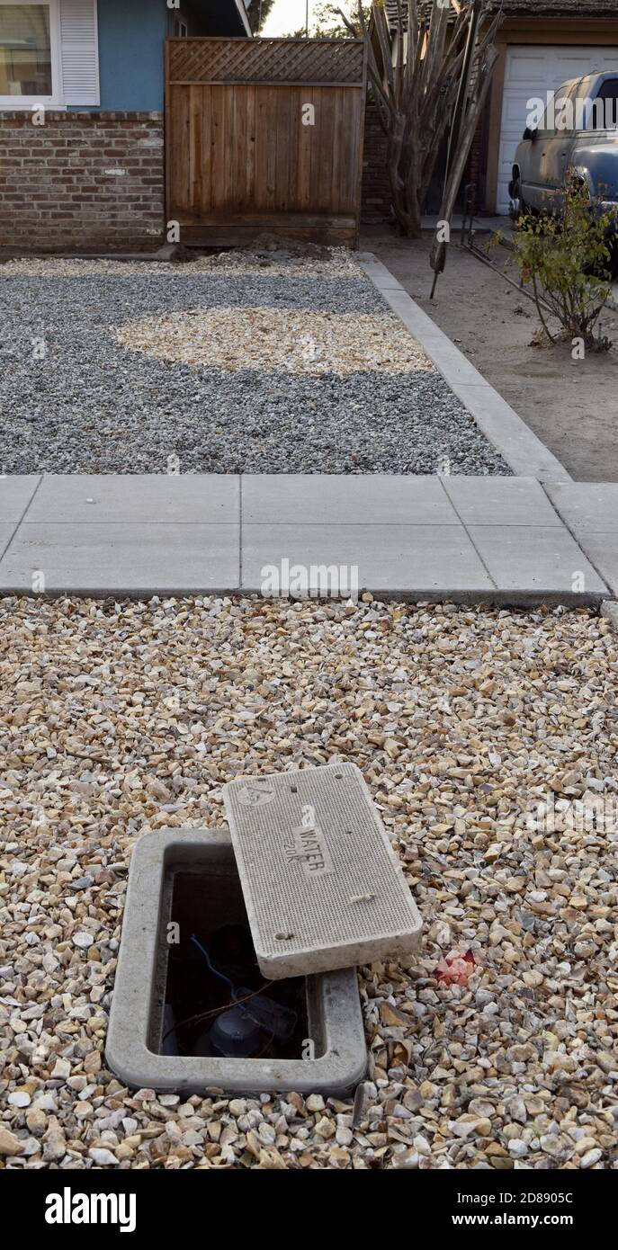 Vertical shot of a water manhole on a gravel yard Stock Photo - Alamy
