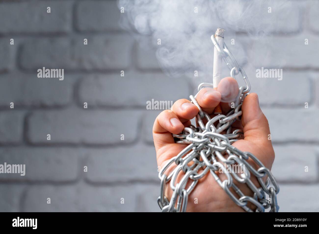 Male hand in metal chains holding cigarette Stock Photo - Alamy
