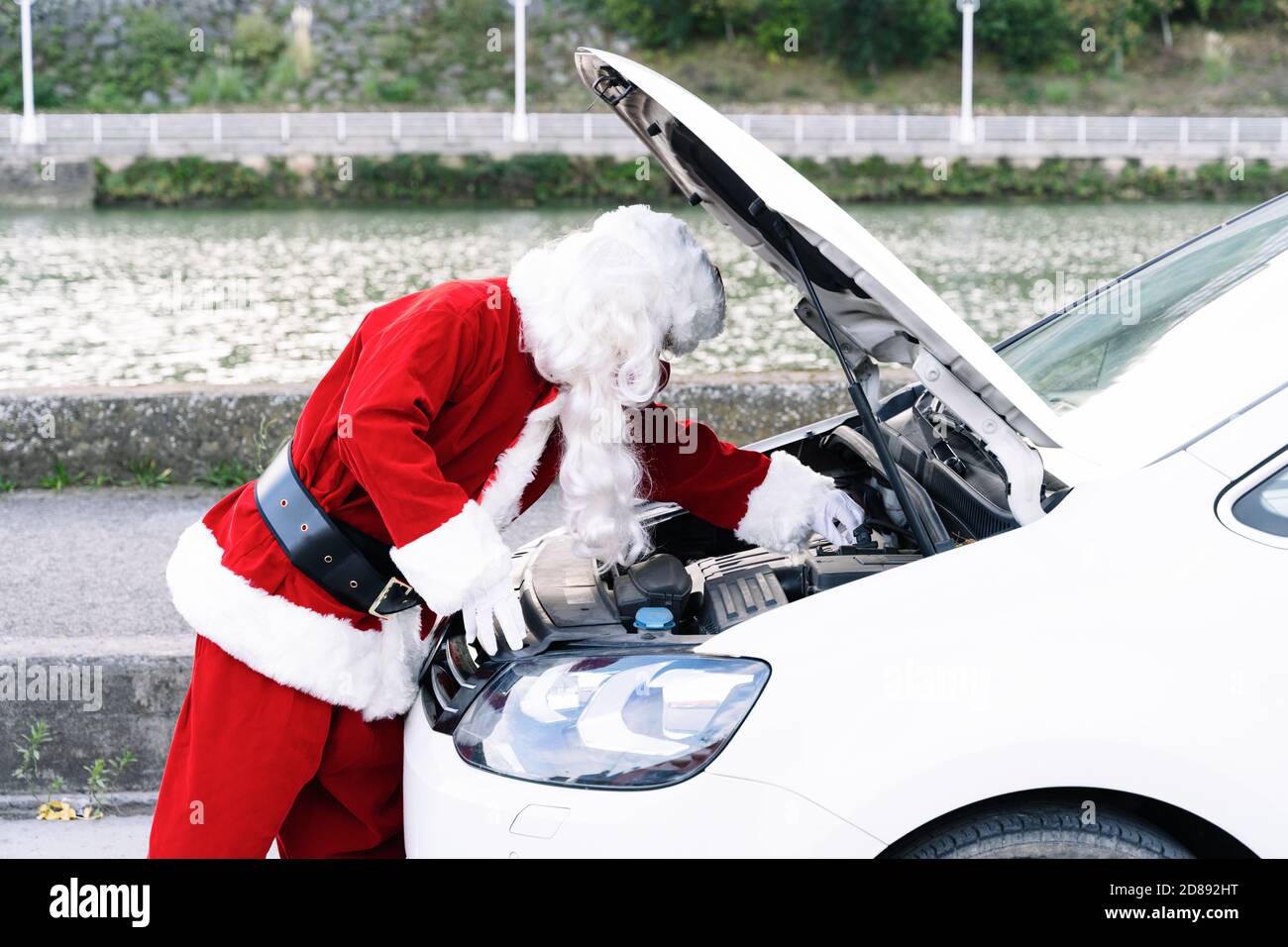 Portrait of Santa Claus with the car bonnet open and touching the ...