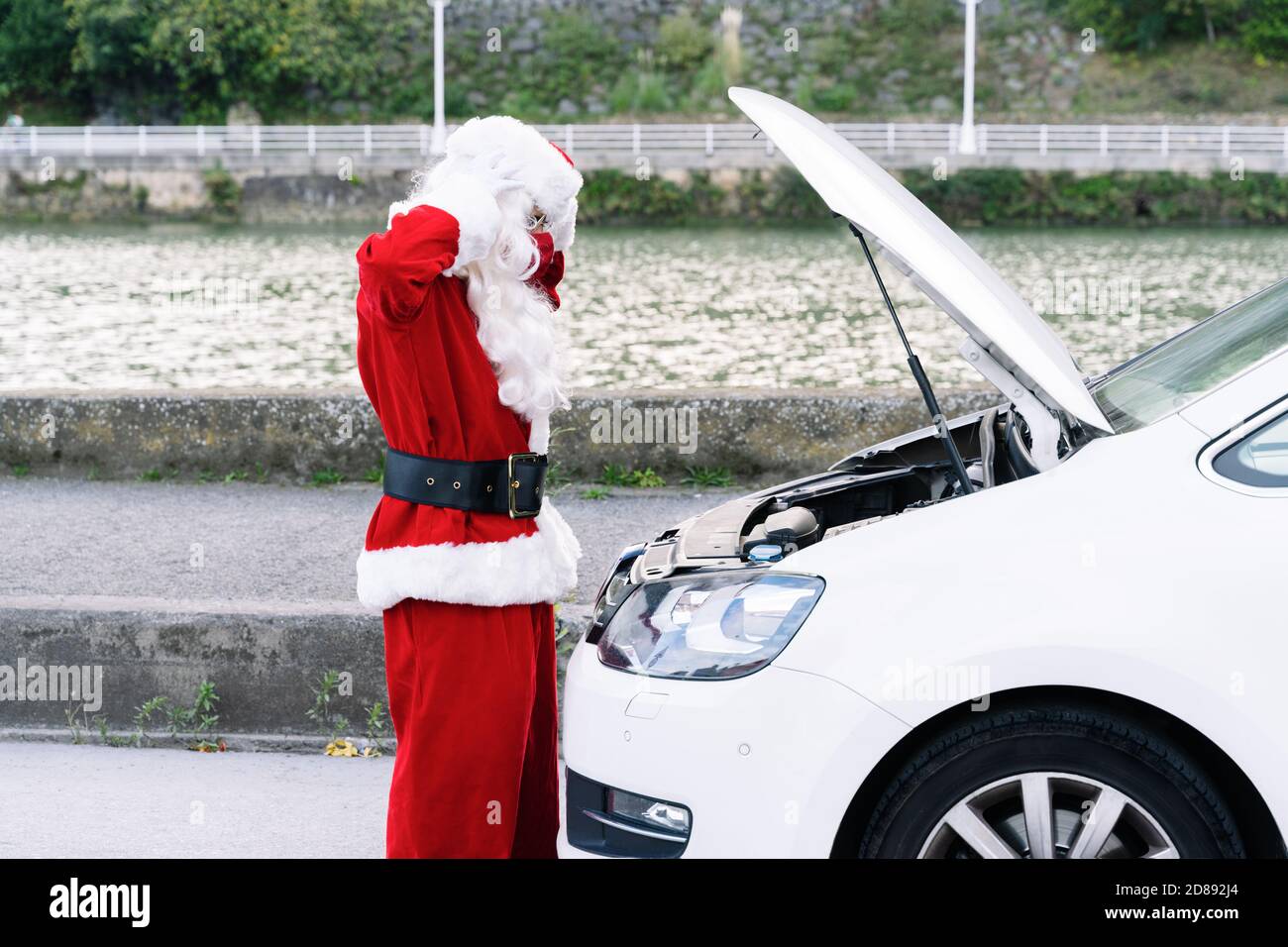 Portrait of Santa Claus with his hands on his head worried with the car ...