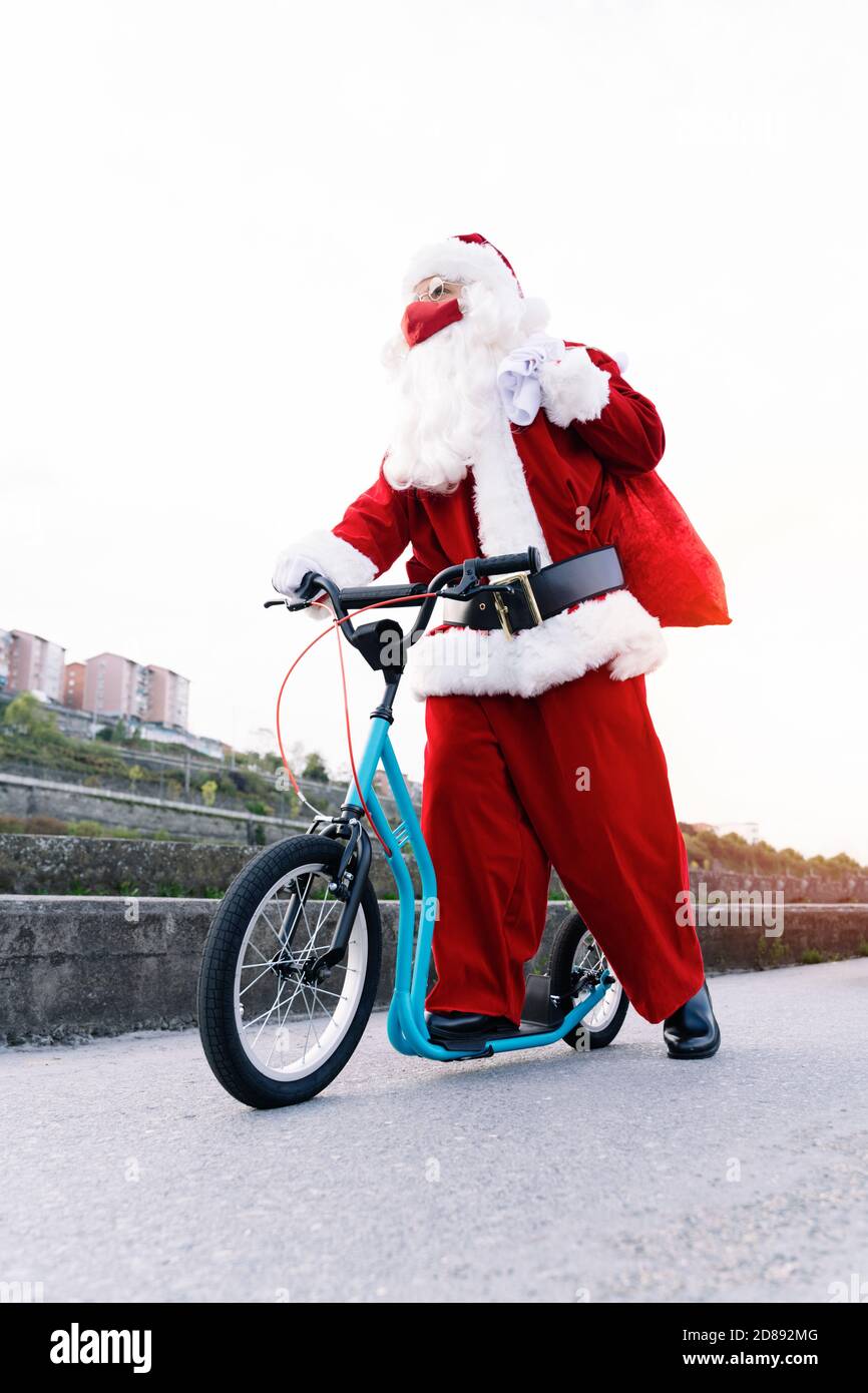 Portrait of Santa Claus with an open car trunk full of gifts driving a ...
