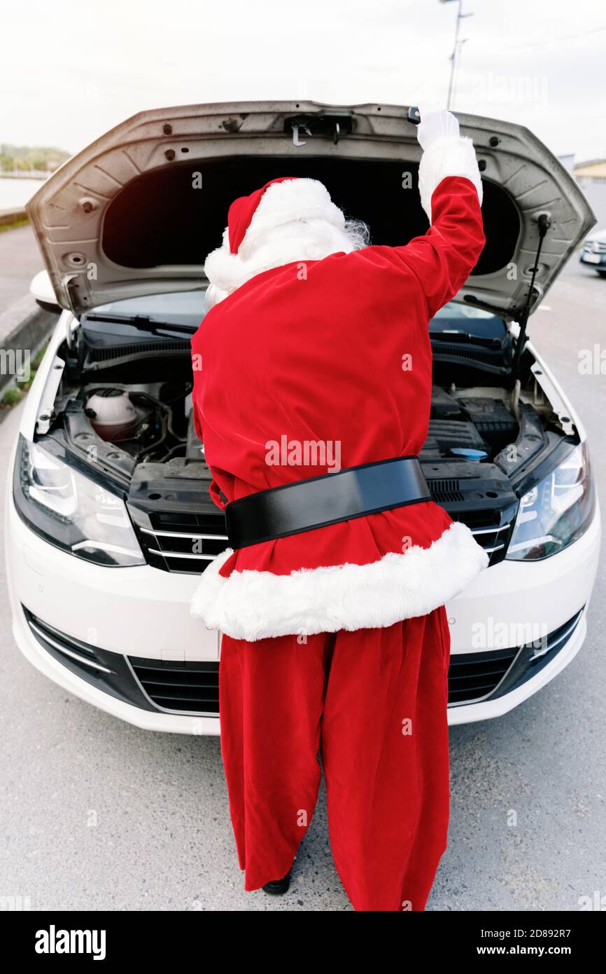back portrait of Santa Claus with the bonnet car and looking at the ...