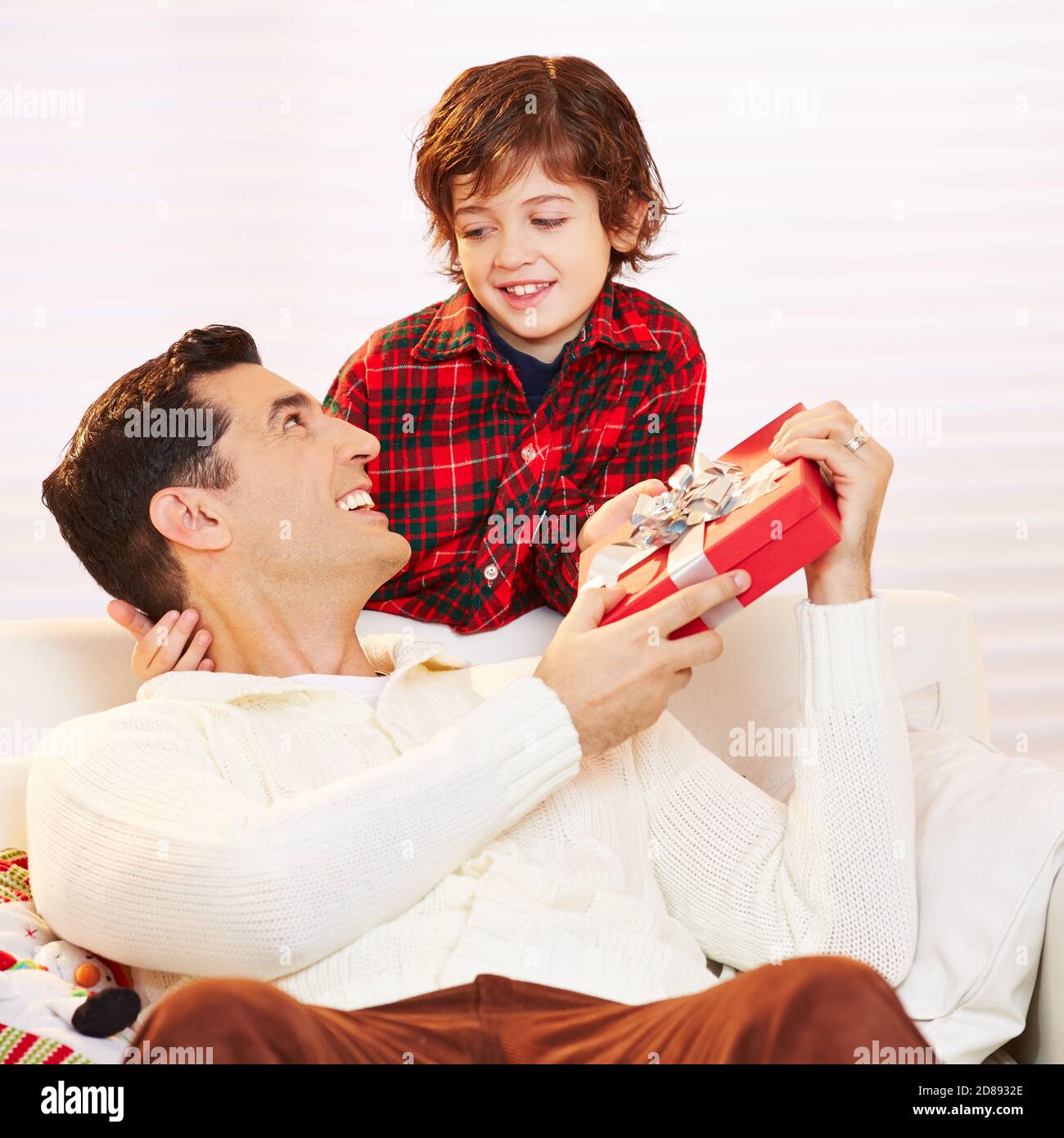 Son gives a gift to happy father for Christmas Stock Photo - Alamy