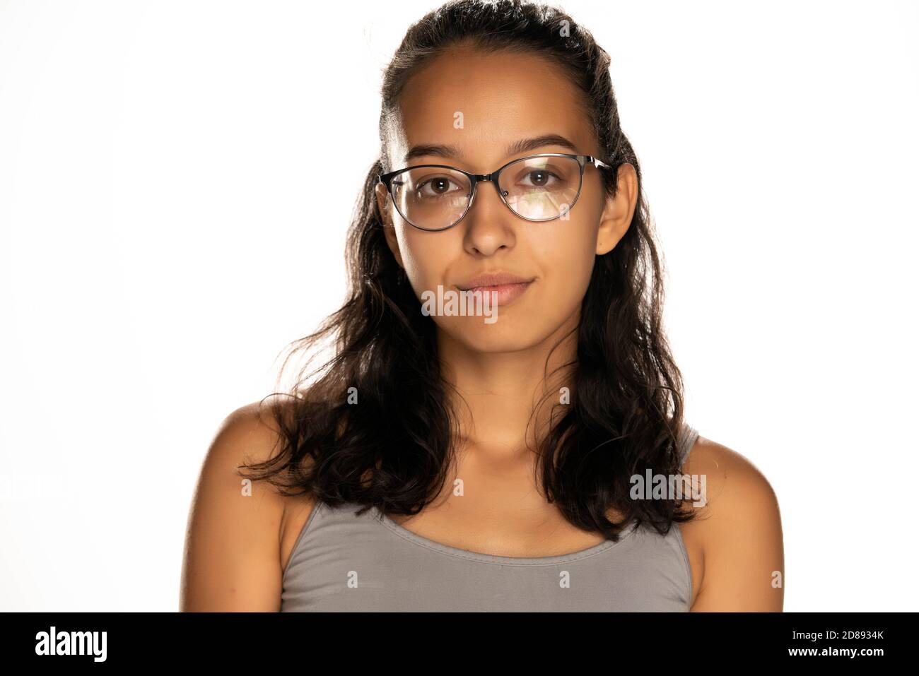 portrait of serious young arabic woman with glasses on white background ...
