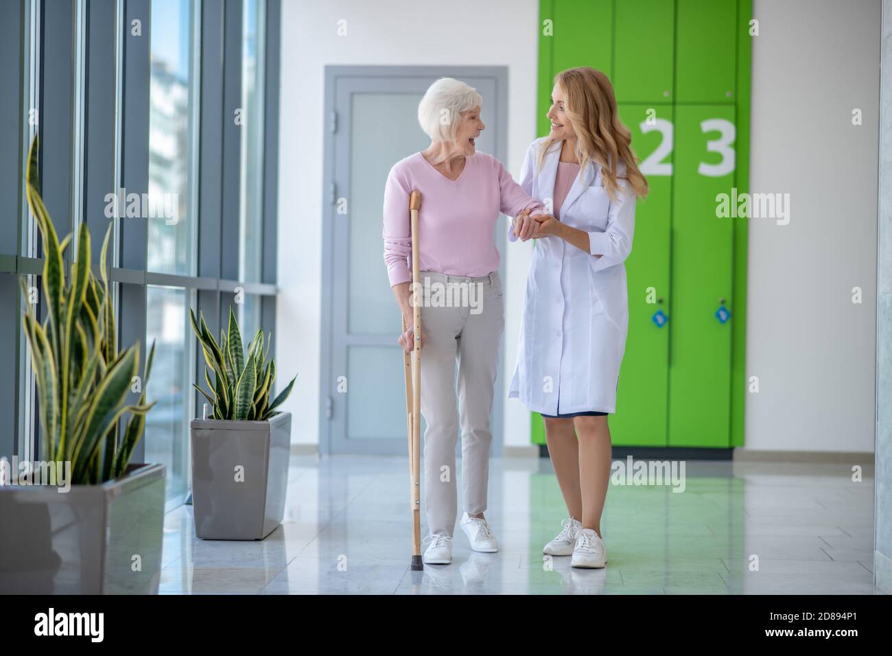 Doctor in a lab coat and a patient walking together Stock Photo - Alamy
