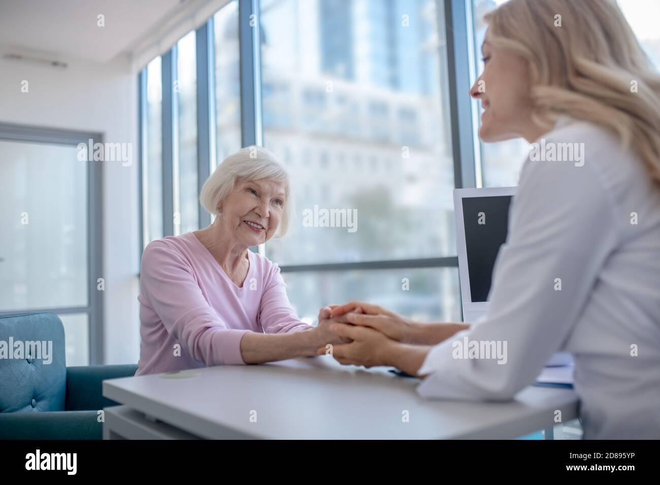 Doctor putting her hand on patients hand showing support and concern ...