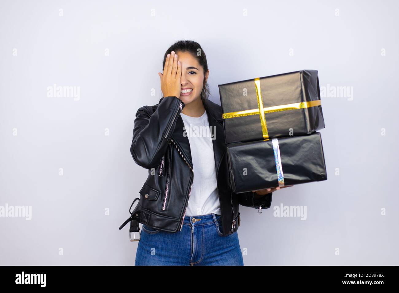 Young beautiful woman holding gifts over isolated white background ...