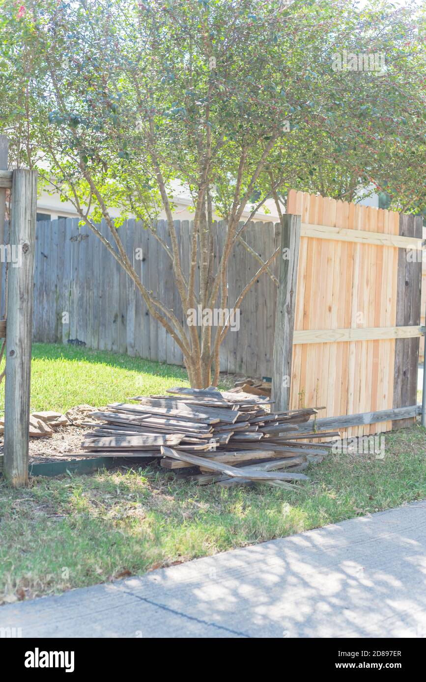 Concrete back alley with old fence near new lumber boards pickets at ...