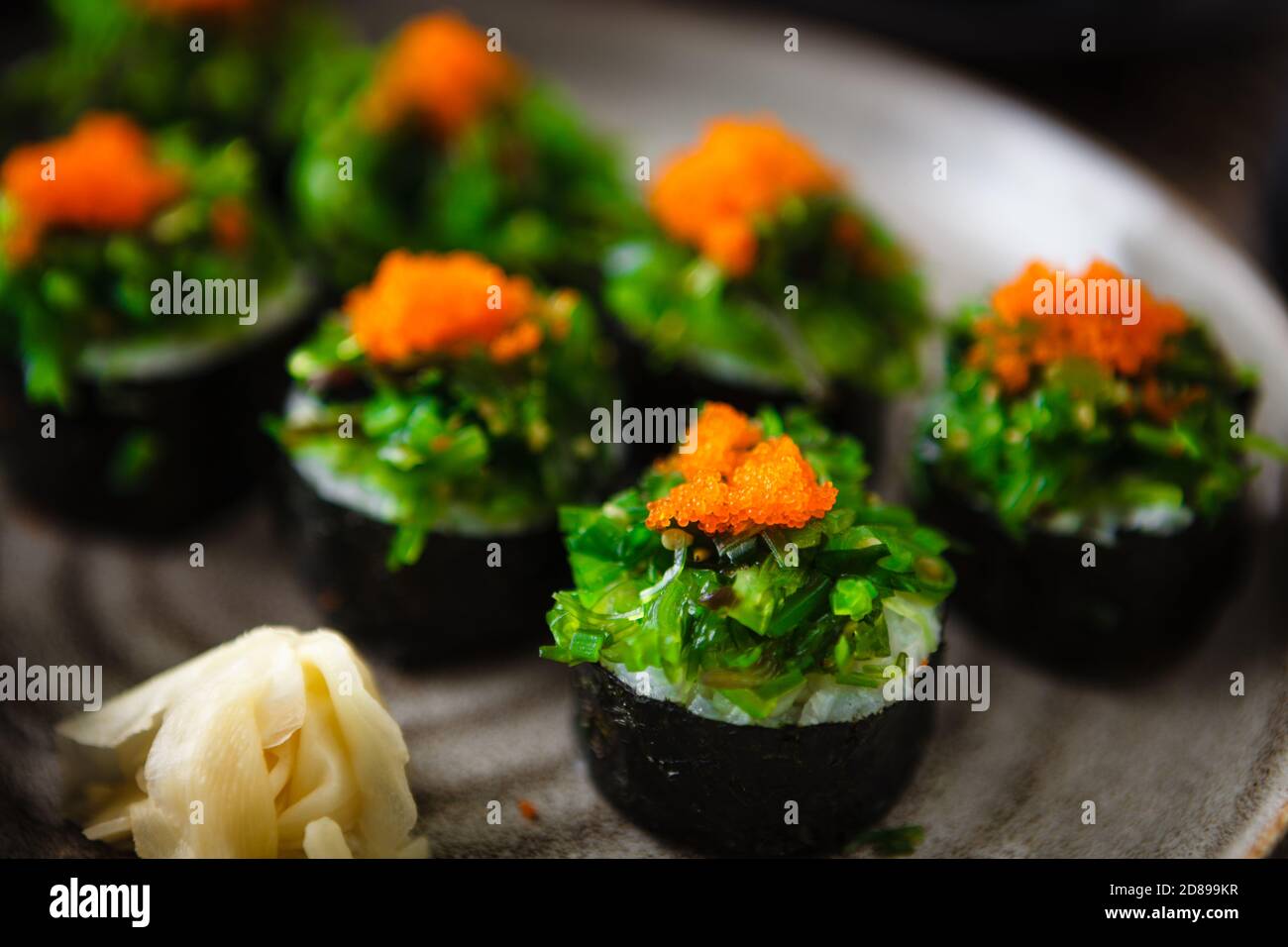Sushi maki rolls with crab, seaweed salad and flying fish roe on a ...