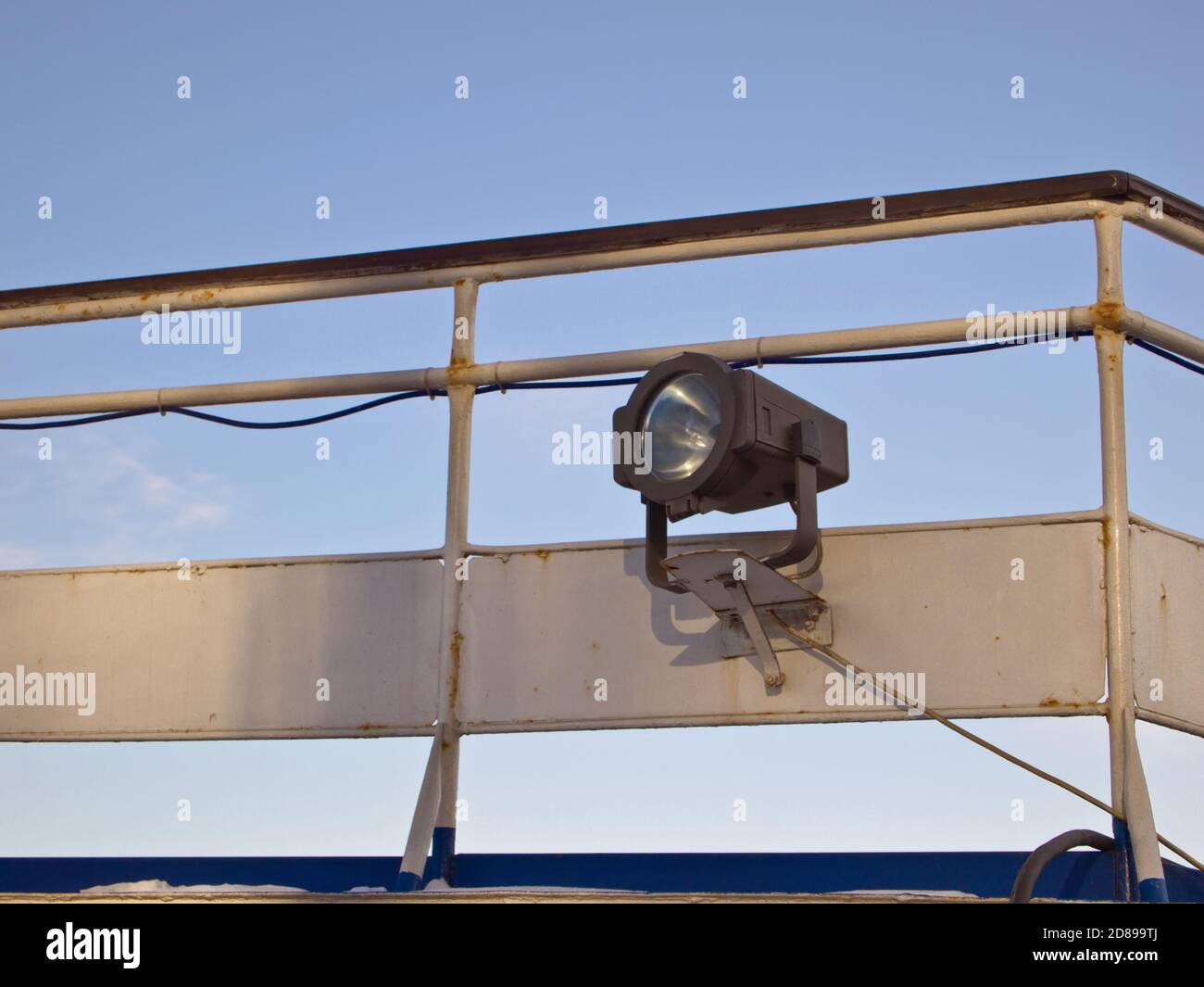 Ship searchlight fixed on enclosure on blue sky Stock Photo - Alamy