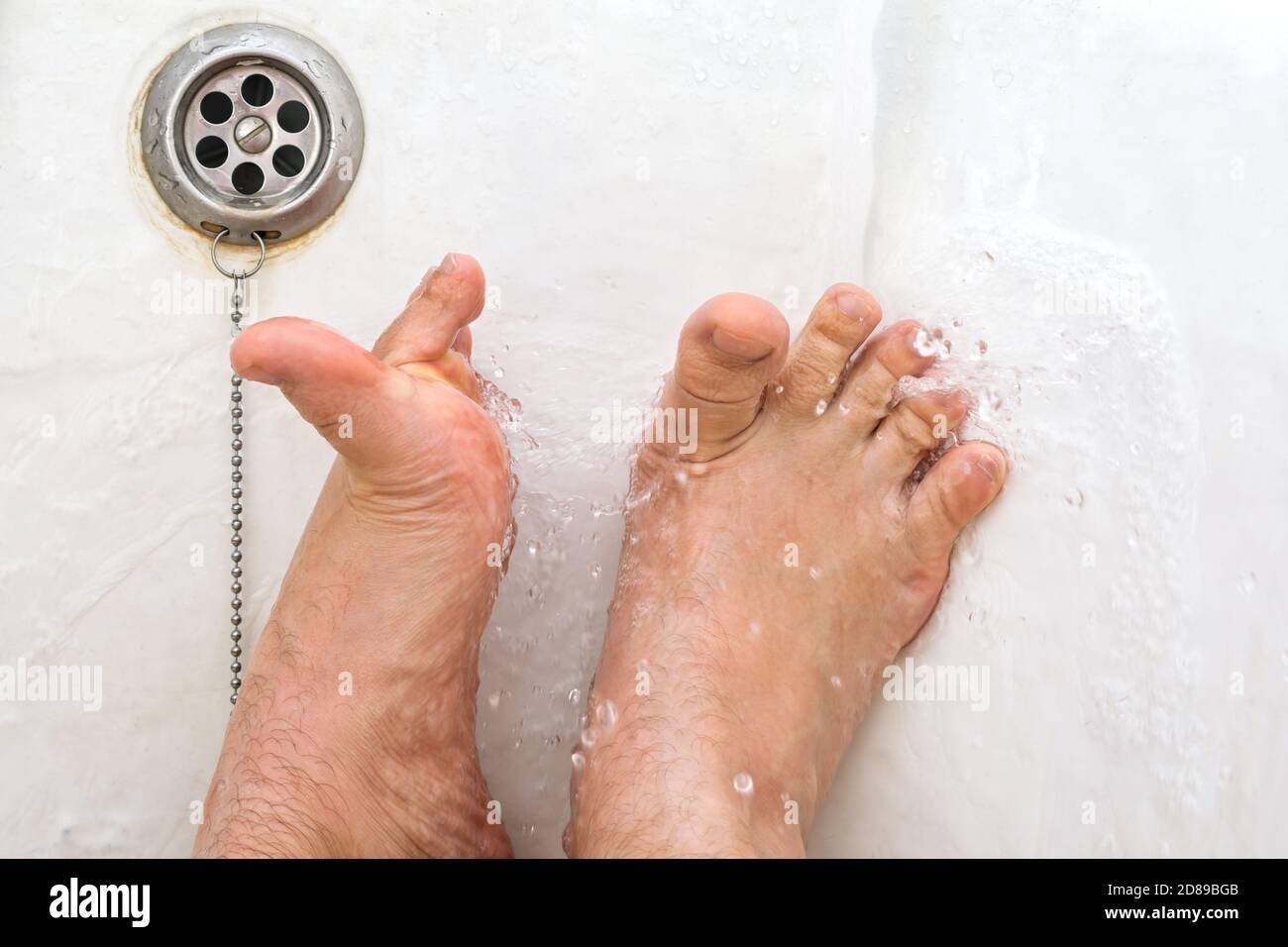 Washing feet in running water while lying in a bathroom close-up Stock ...