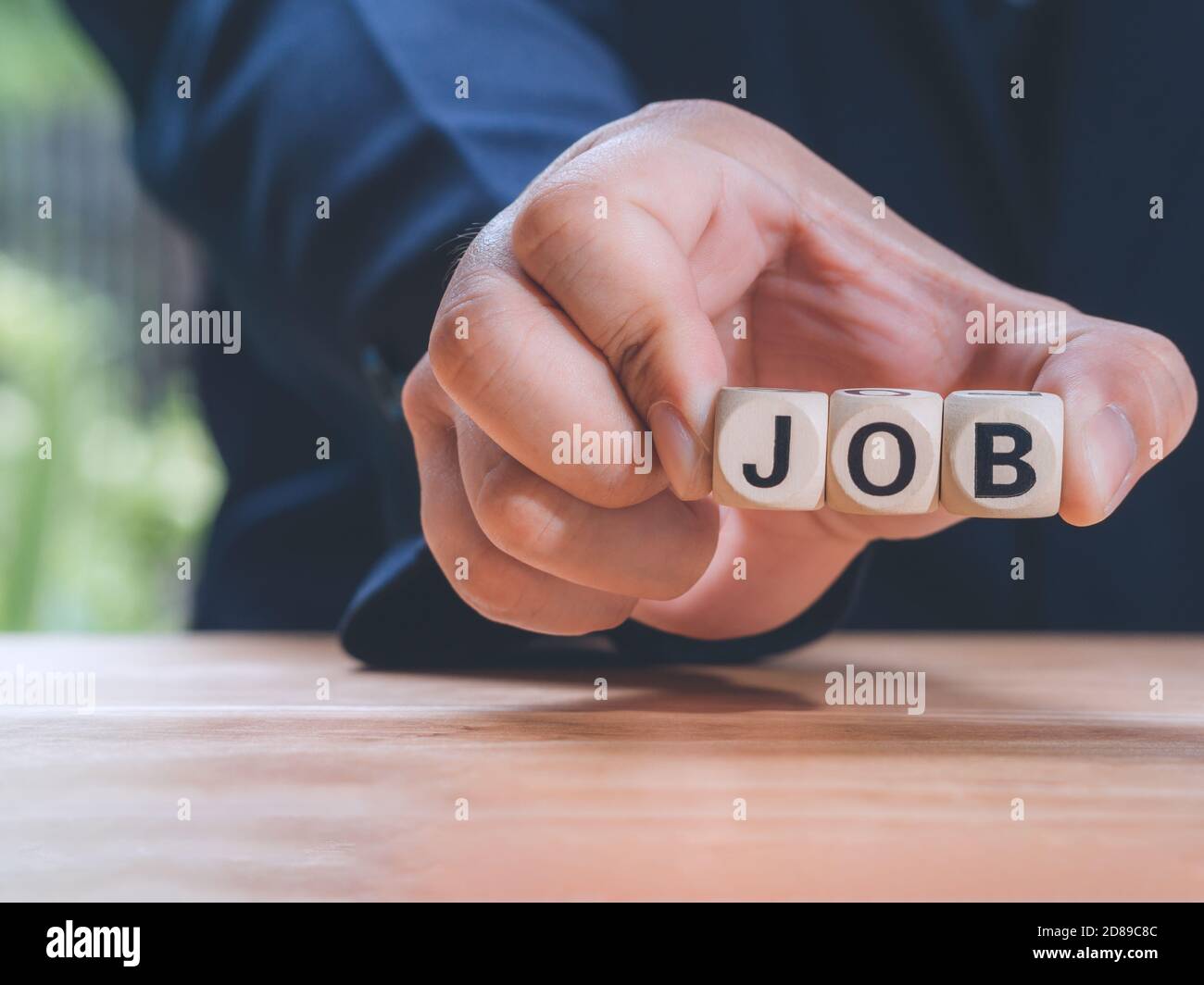 Closeup of businessman's giving wooden block written JOB text to ...