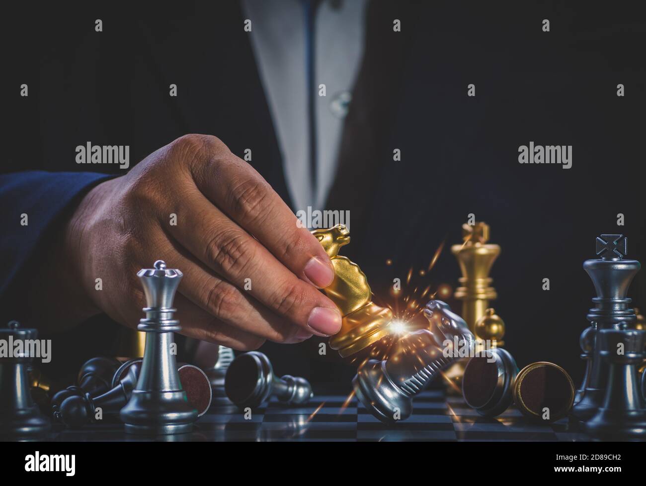 Hand businessman moving the golden knight chess fighting silver knight ...