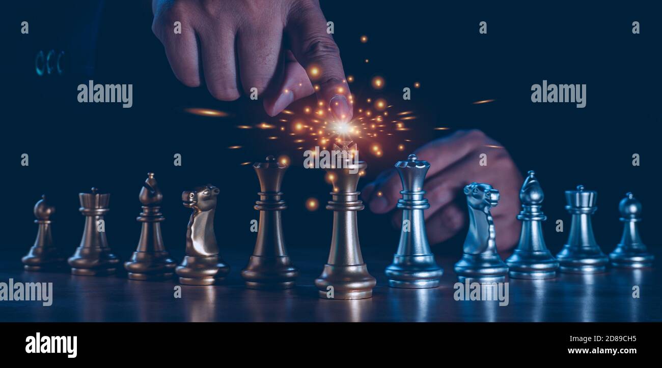 Hand businessman moving the golden knight chess fighting silver knight ...