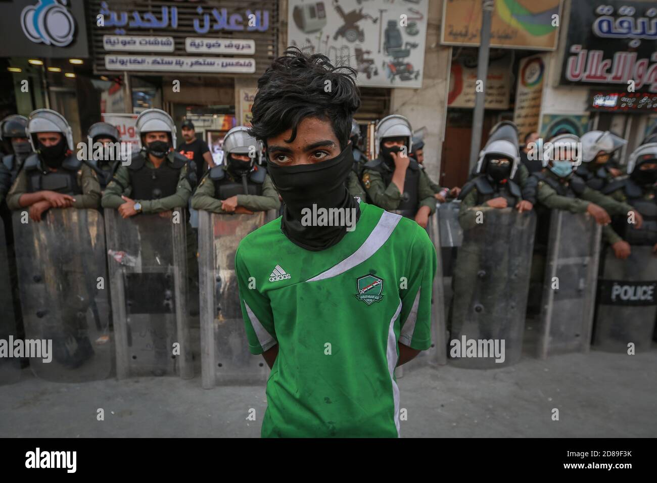 Baghdad, Iraq. 28th Oct, 2020. A man stands in front of Iraqi soldiers ...