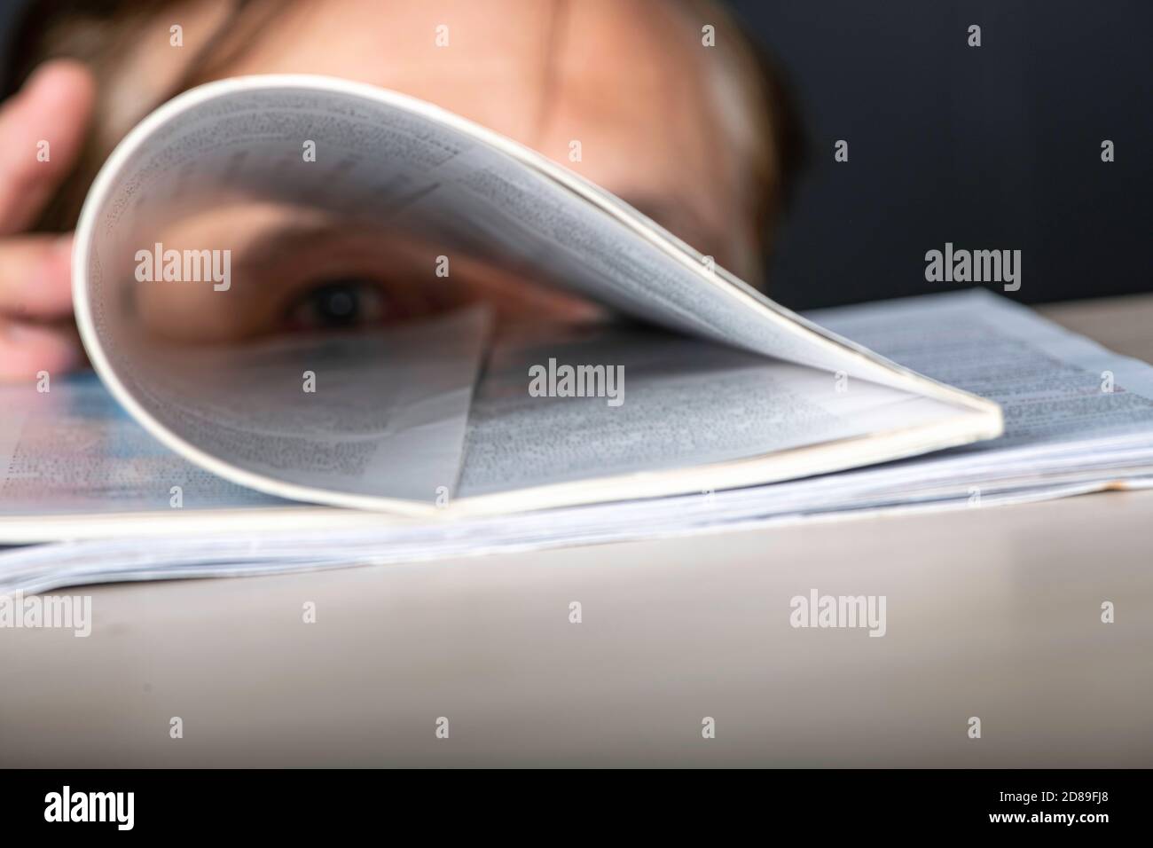 Man looking through folded pages of a magazine Stock Photo - Alamy
