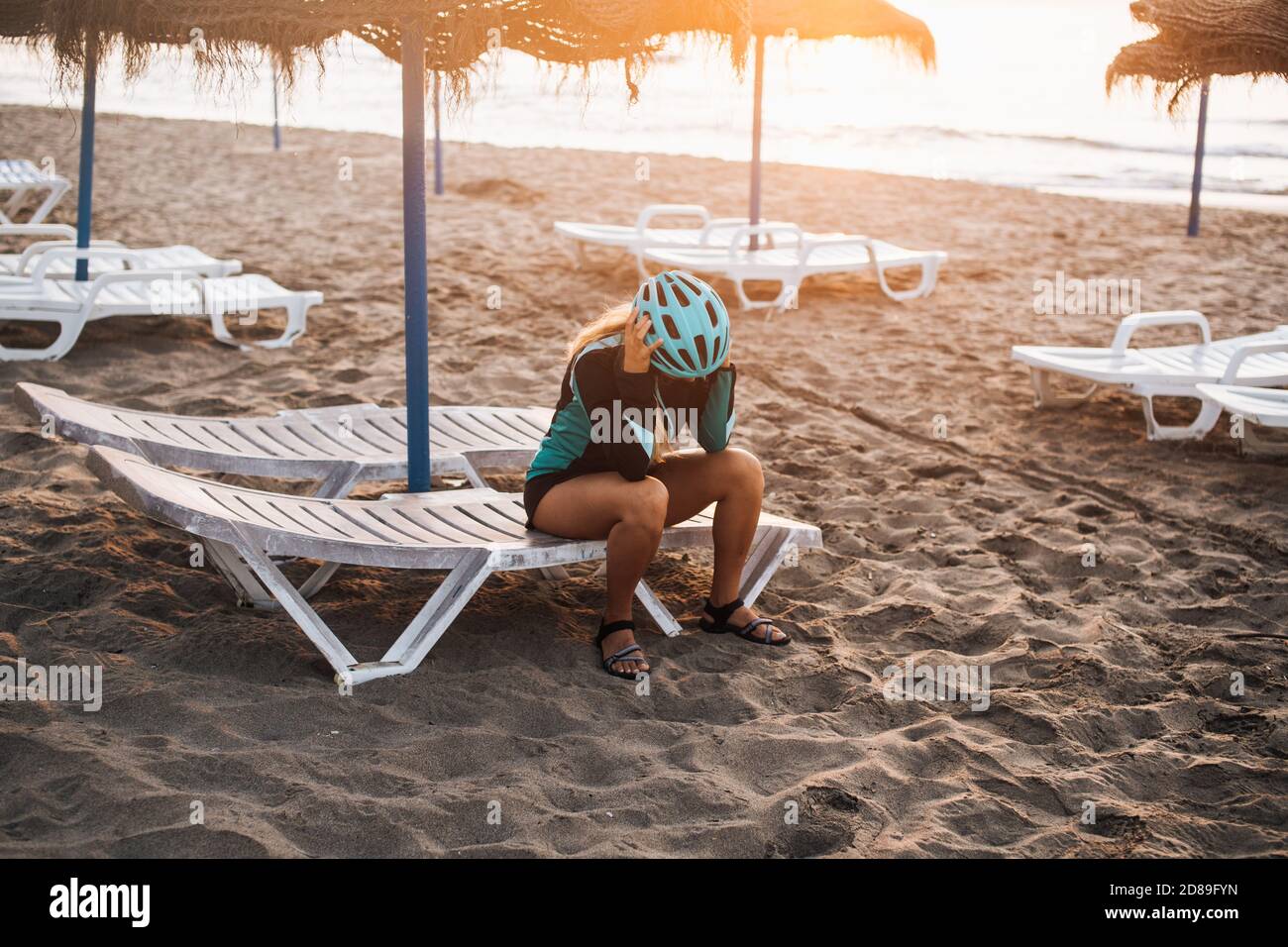 Stressed cyclist in the beach with her head in her hands, Fuengirola ...