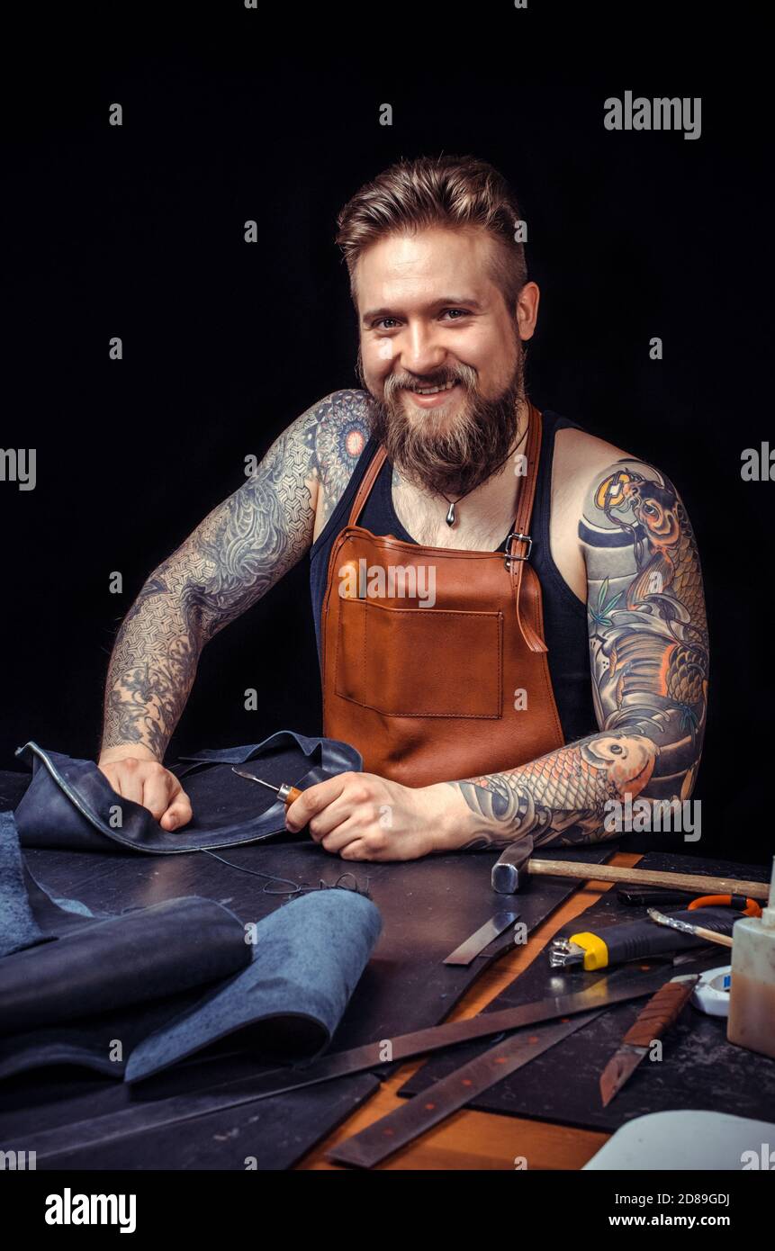 Leather man producing leather workpiece at the desk Stock Photo - Alamy
