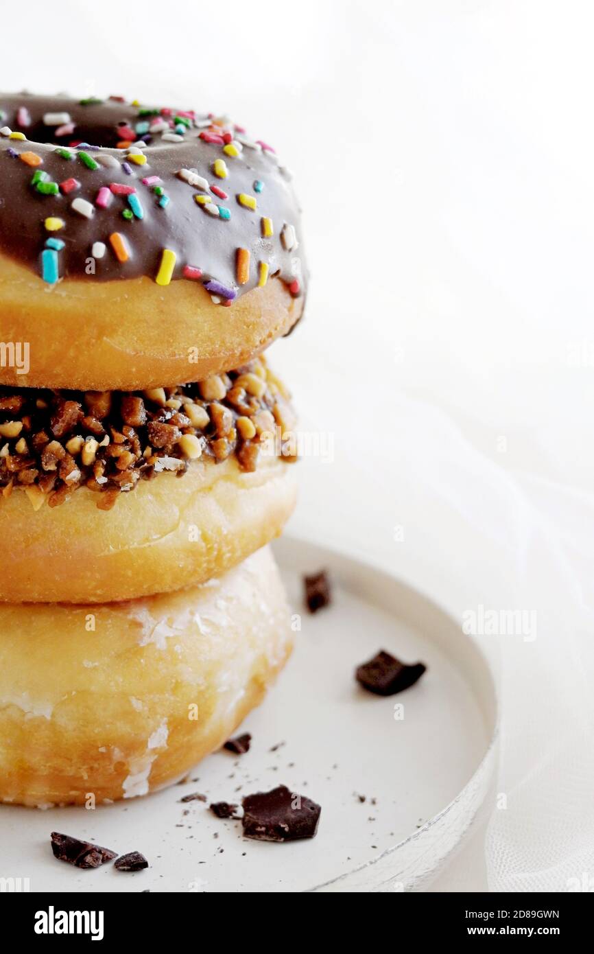 Close-up of a stack of three doughnuts on a plate Stock Photo - Alamy