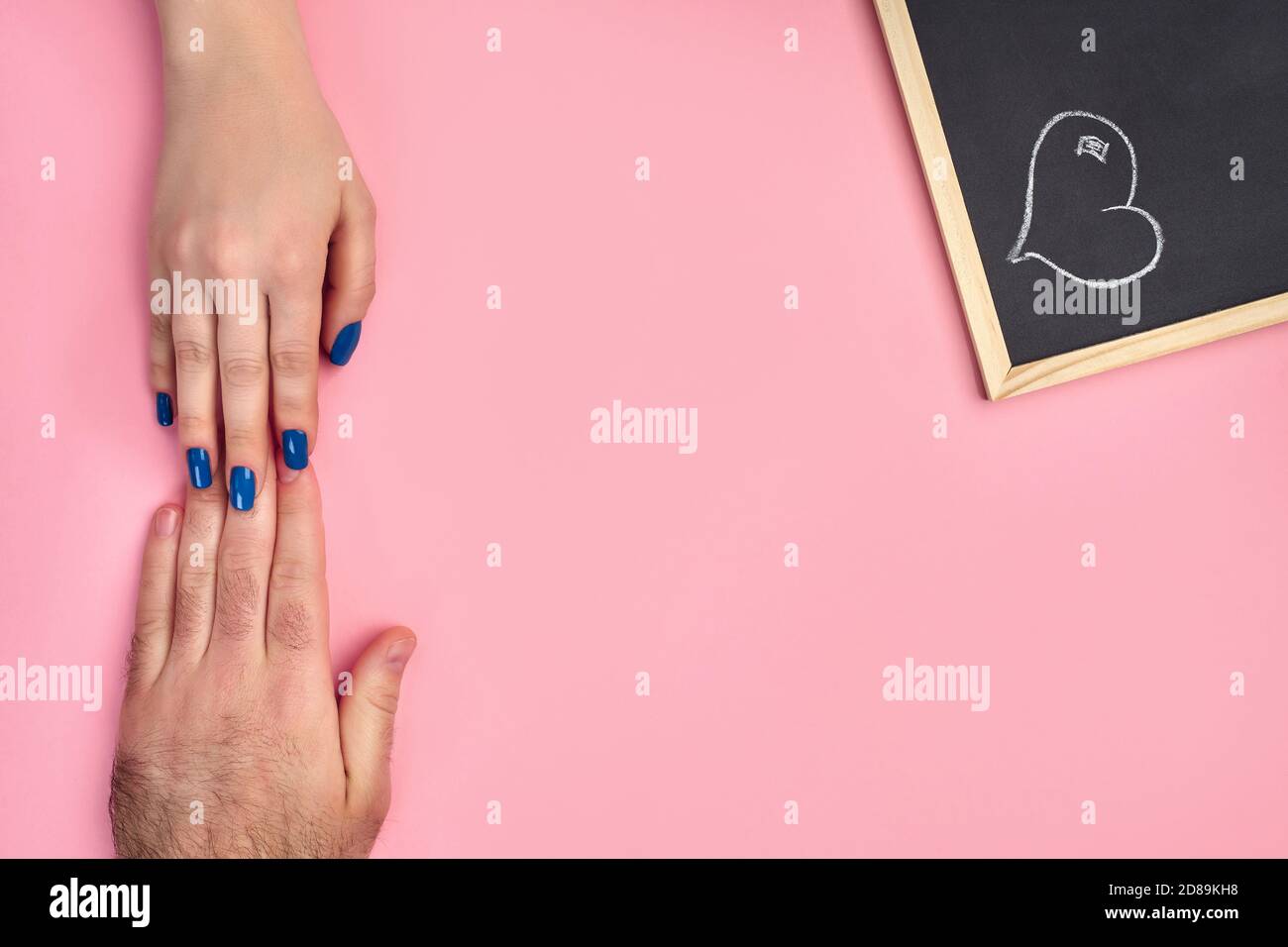 Hand of unknown female is touching a mans one against pink background ...