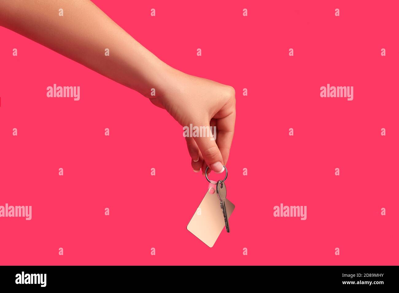 Hand of unknown woman is holding a key with blank white square plastic ...