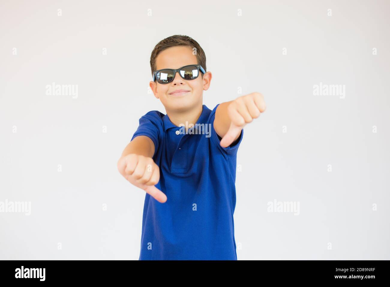 Kid wearing sunglasses making bad sign over white background Stock ...