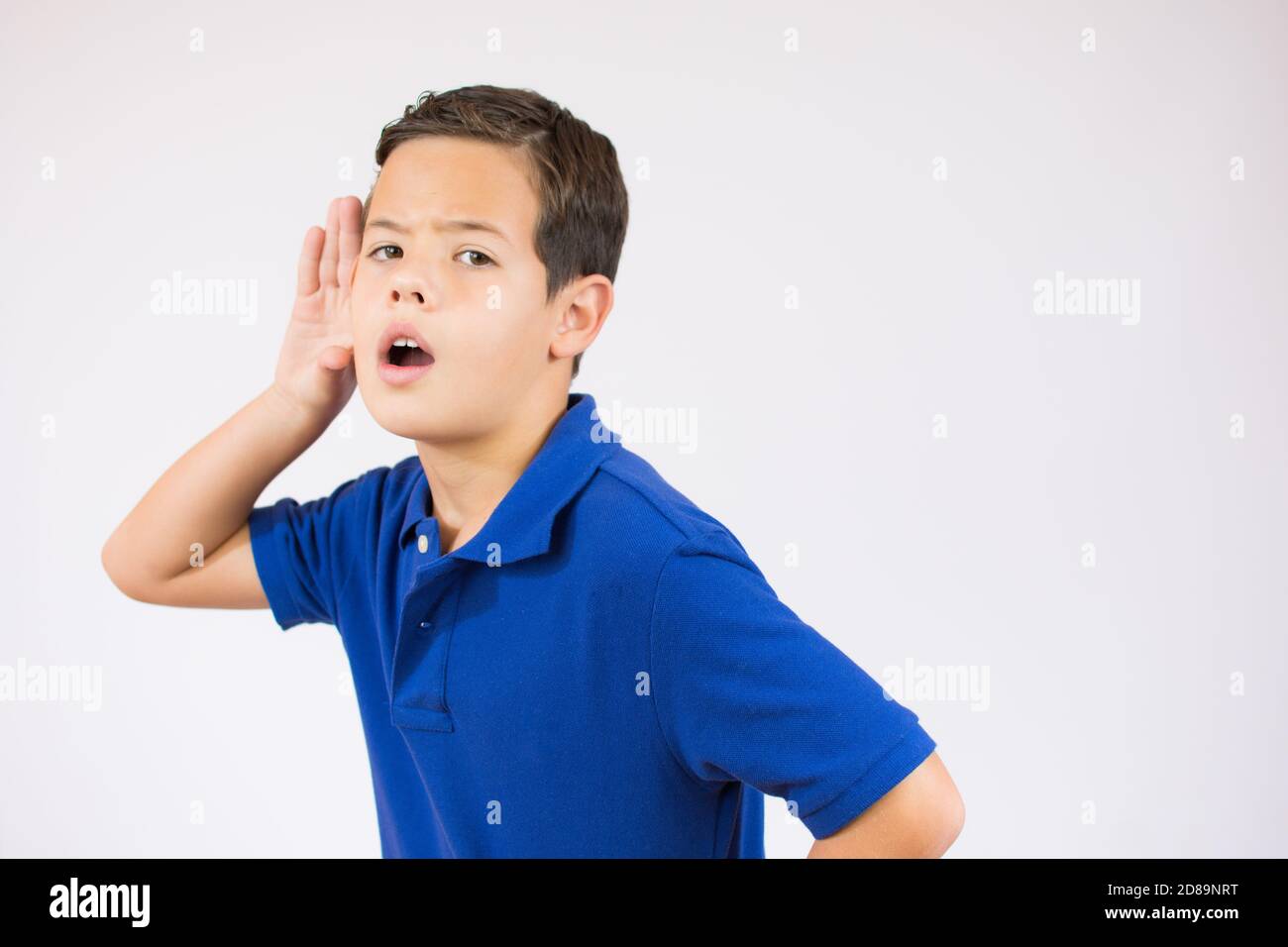 Boy in blue t-shirt making hearing gesture on white background. facial ...